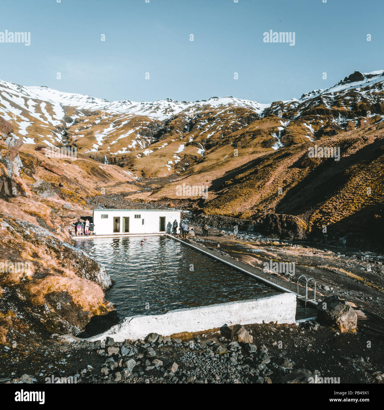 Natural swimming pool Seljavallalaug in iceland with man in water and ...