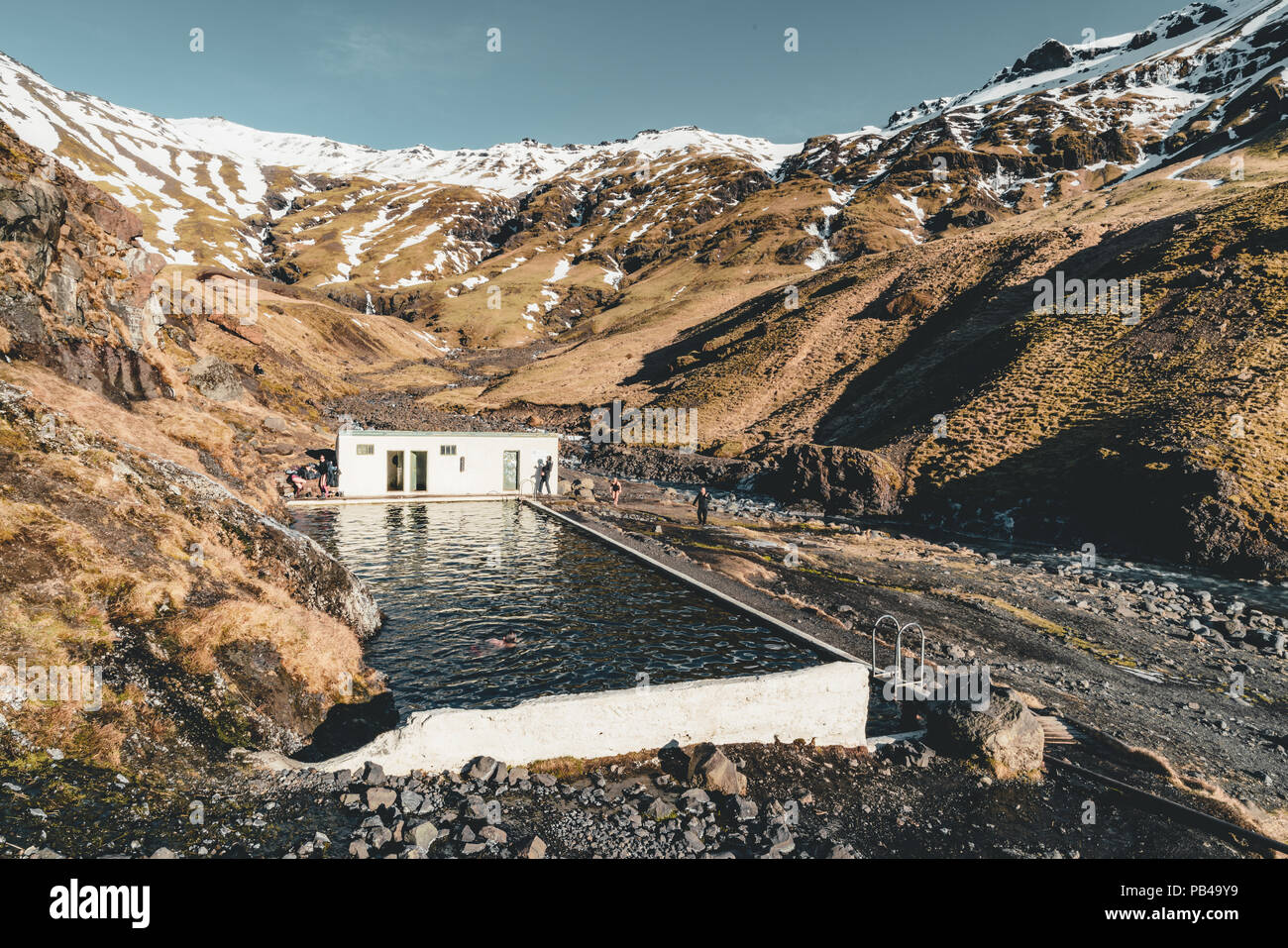 Natural swimming pool Seljavallalaug in iceland with man in water and ...