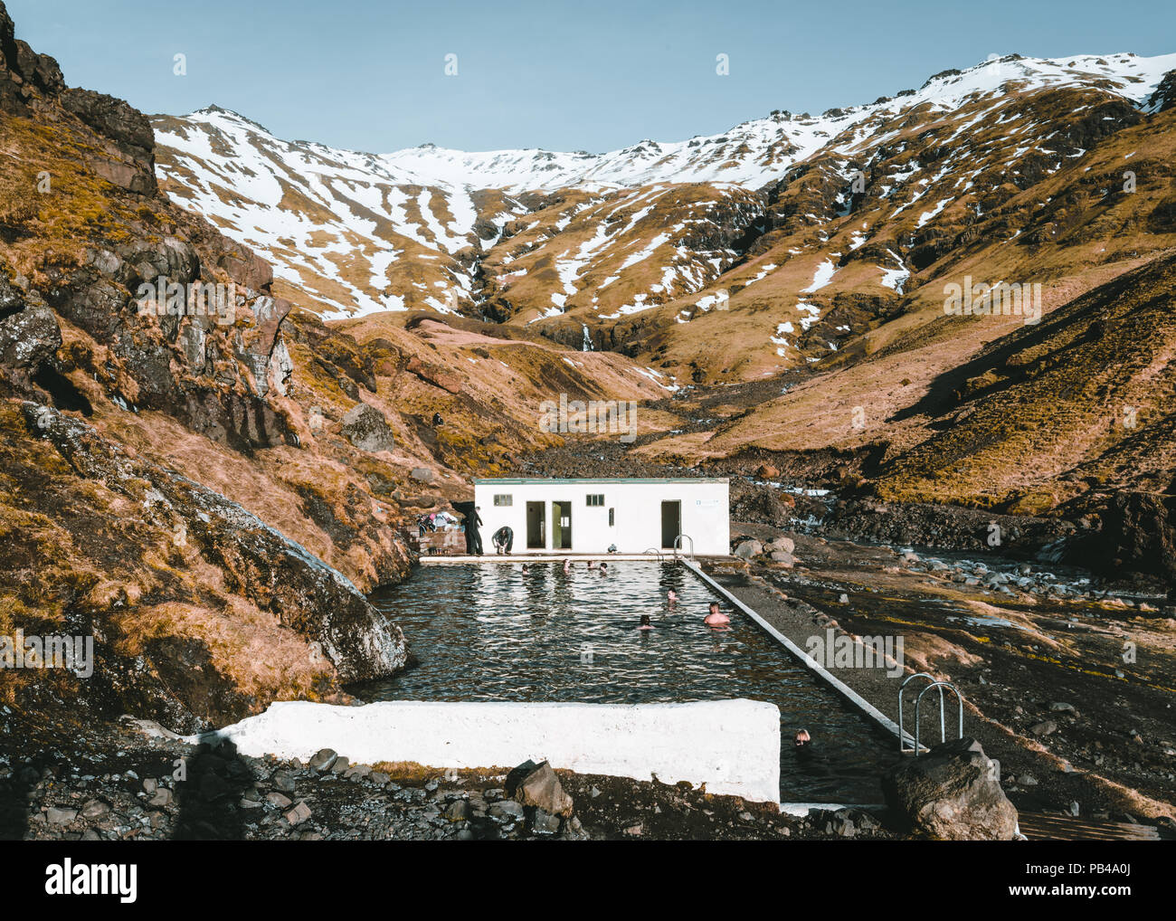Natural swimming pool Seljavallalaug in iceland with man in water and ...