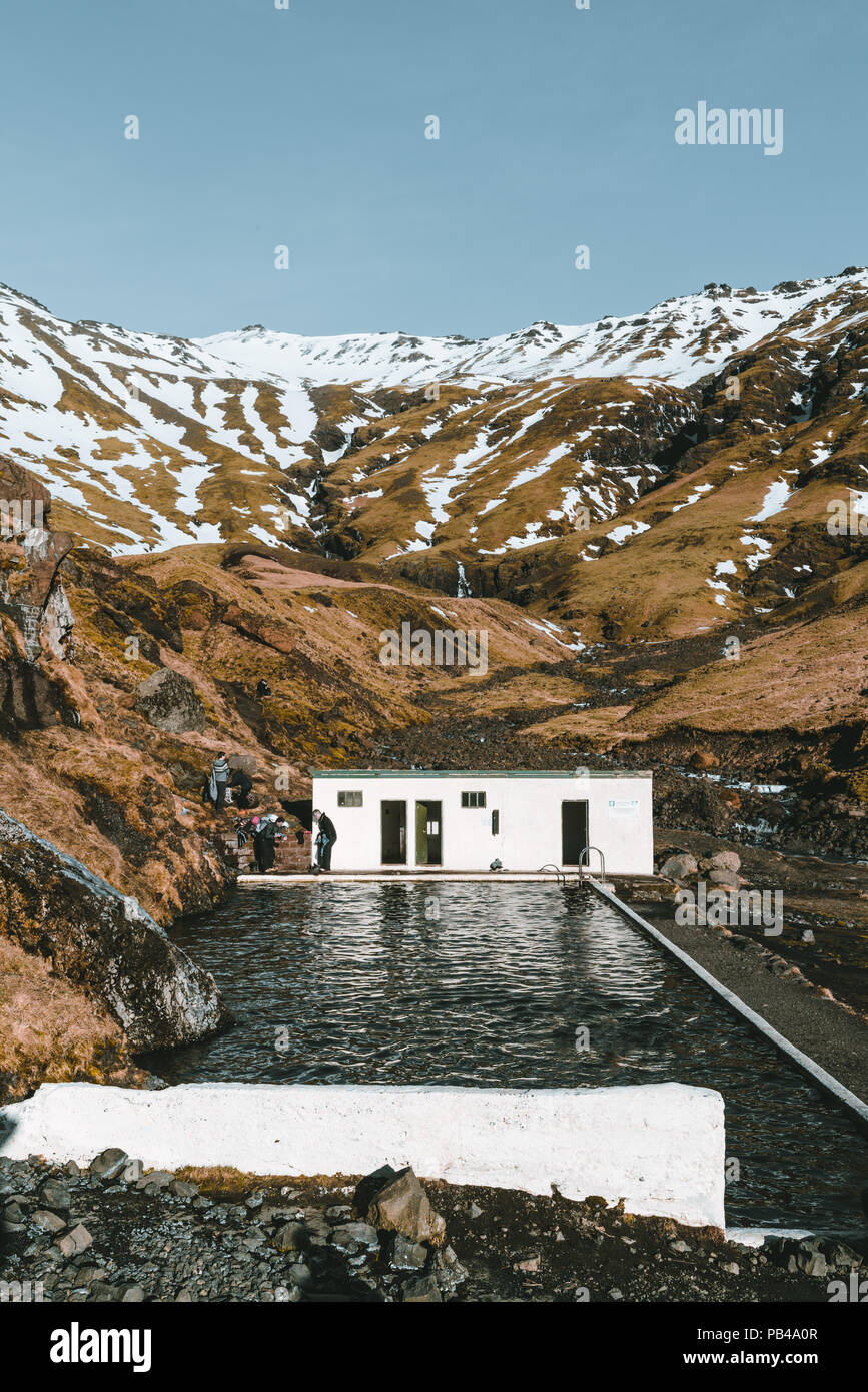 Natural swimming pool Seljavallalaug in iceland with man in water and ...