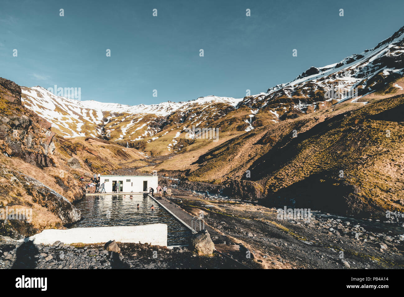 Natural swimming pool Seljavallalaug in iceland with man in water and ...