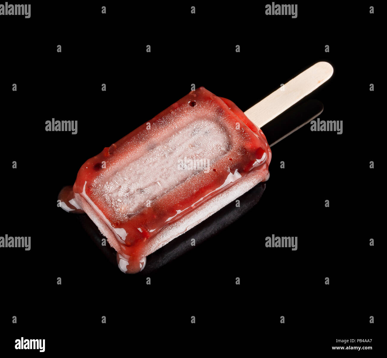 red bean popsicle starts melting on a black background Stock Photo - Alamy