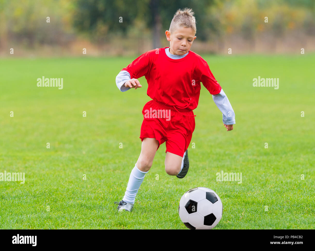 Boy kicking soccer ball hi-res stock photography and images - Alamy