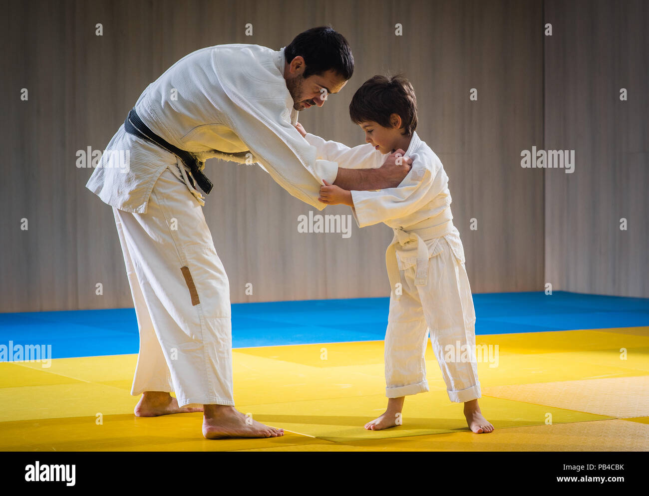Man and young boy are training judo throwing Stock Photo - Alamy
