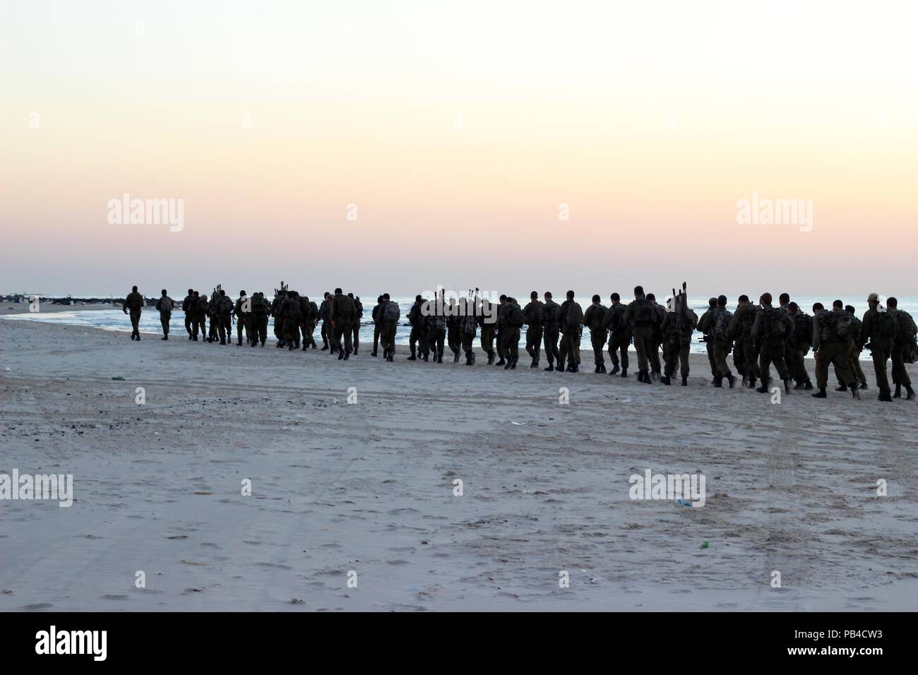 a convoy of soldiers marching on the beach Stock Photo - Alamy