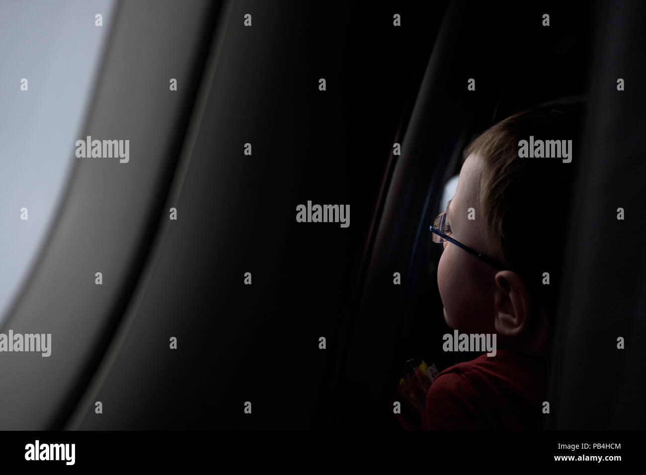 A child looks out of the airplane window during a flight Stock Photo ...