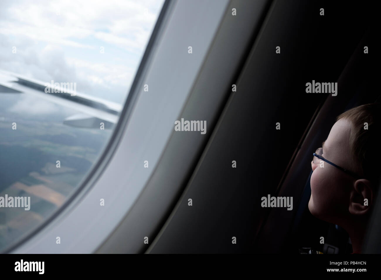 A child looks out of the airplane window during a flight Stock Photo ...