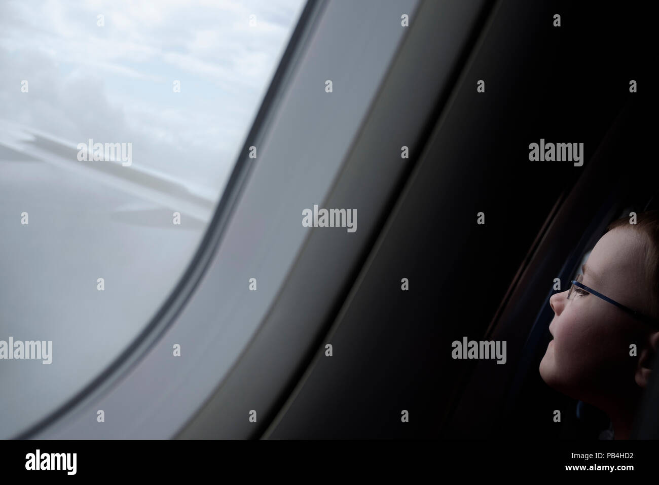 A child looks out of the airplane window during a flight Stock Photo ...