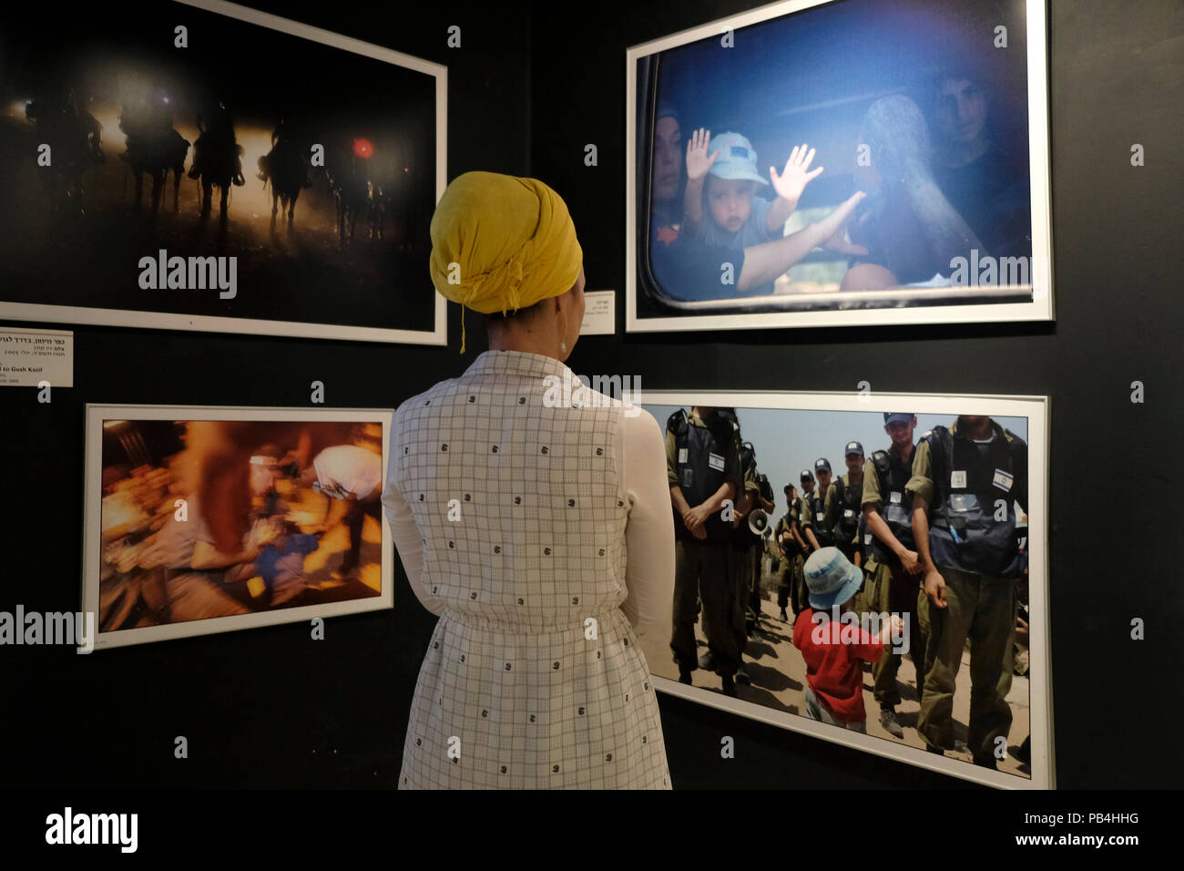 A religious Jewish woman looking at photographs which shows Israeli ...