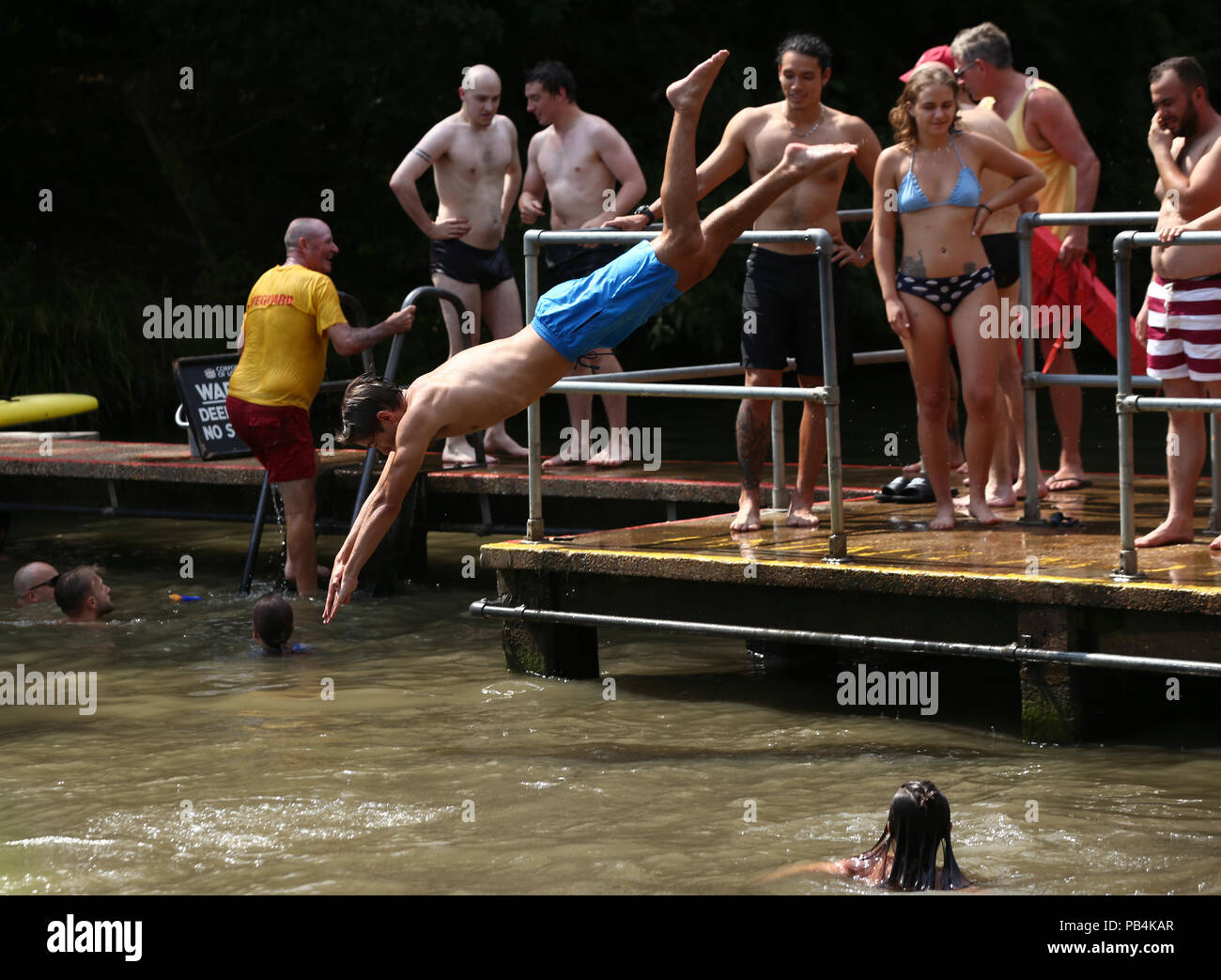 A man dives into the mixed bathing pond on Hampstead Heath, London, as heatwave conditions ...