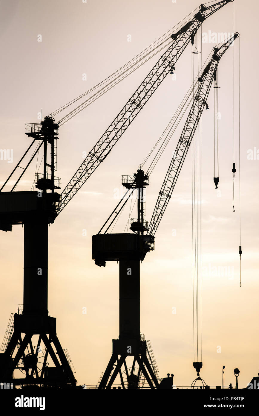 Cranes in the harbor at sunset Stock Photo - Alamy
