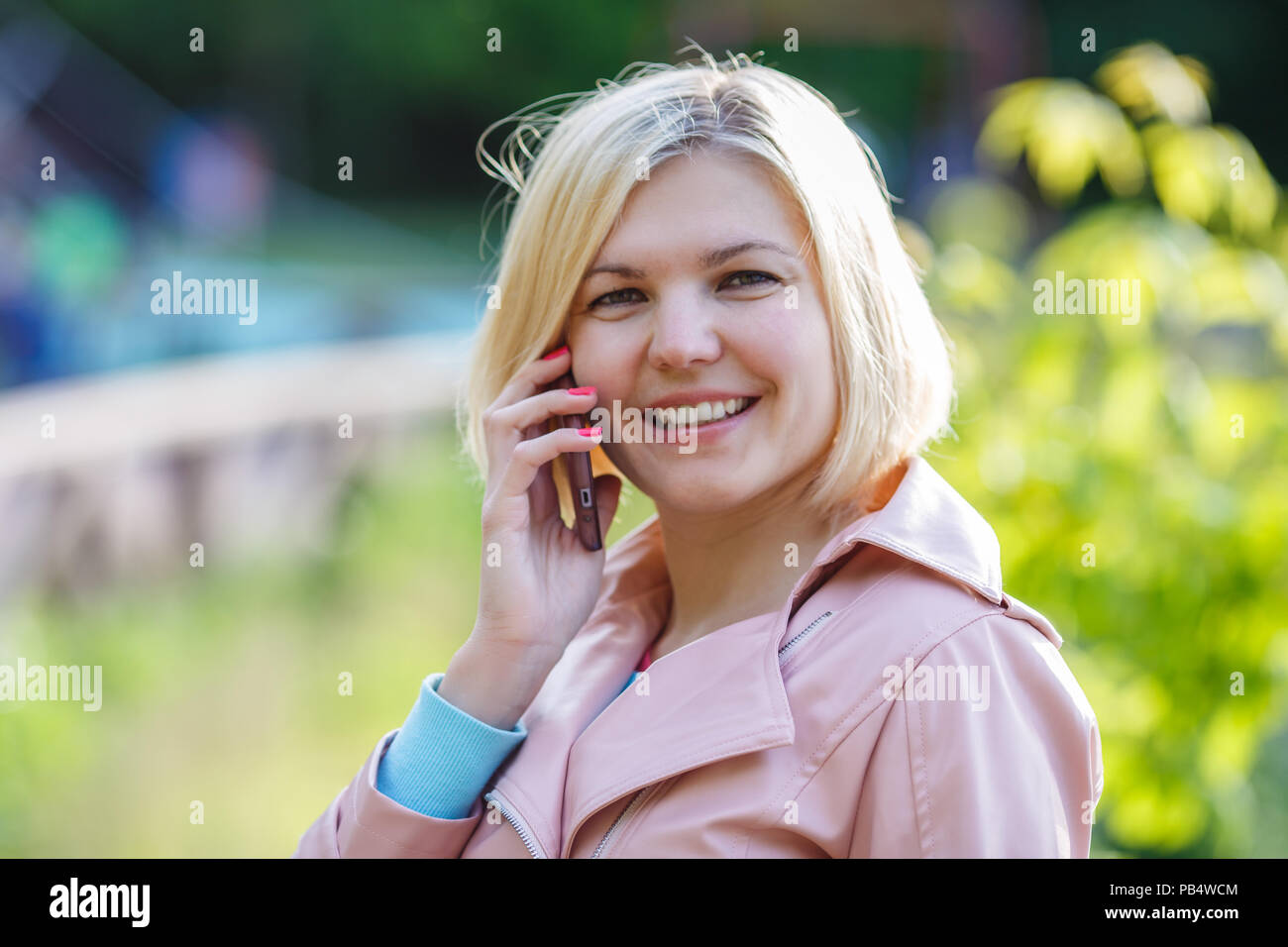 Woman in park with phone Stock Photo - Alamy