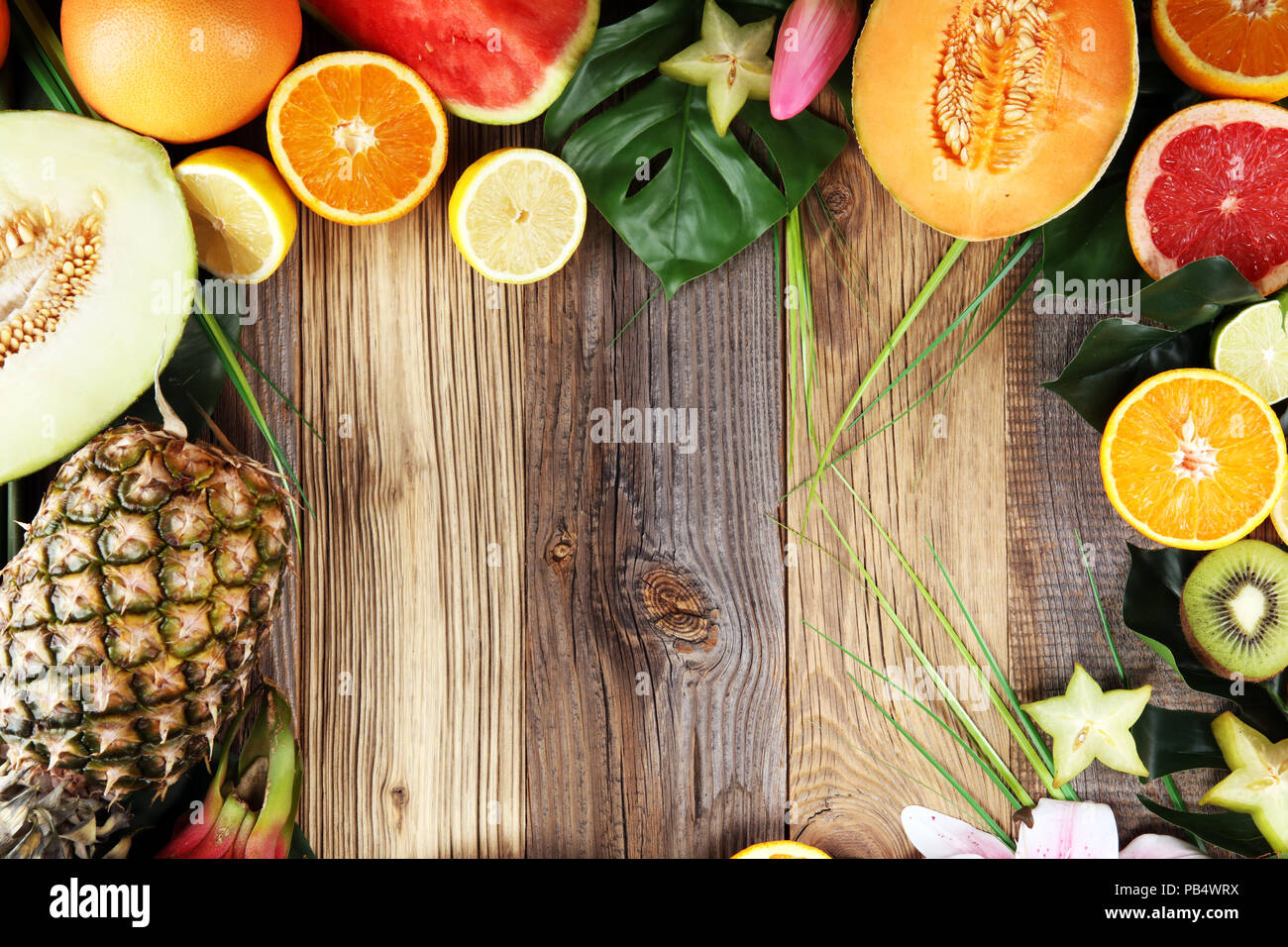 Tropical fruit. Assortment of tropical fruits with leaves of palm trees ...