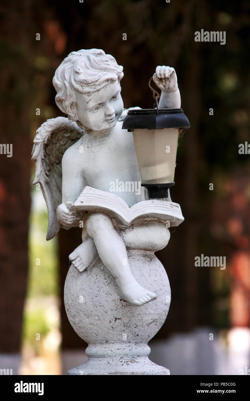 Funerary statue of a child angel in the cemetery Stock Photo - Alamy