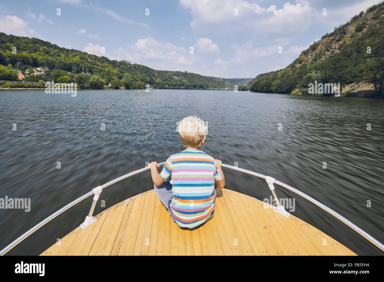 Little boy sitting on the bow of the boat. Summer vacations on the ...