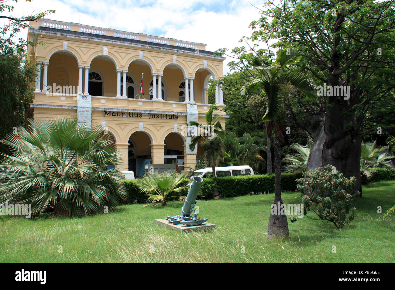 Huge tropical trees and a mortar are located in front of the French ...