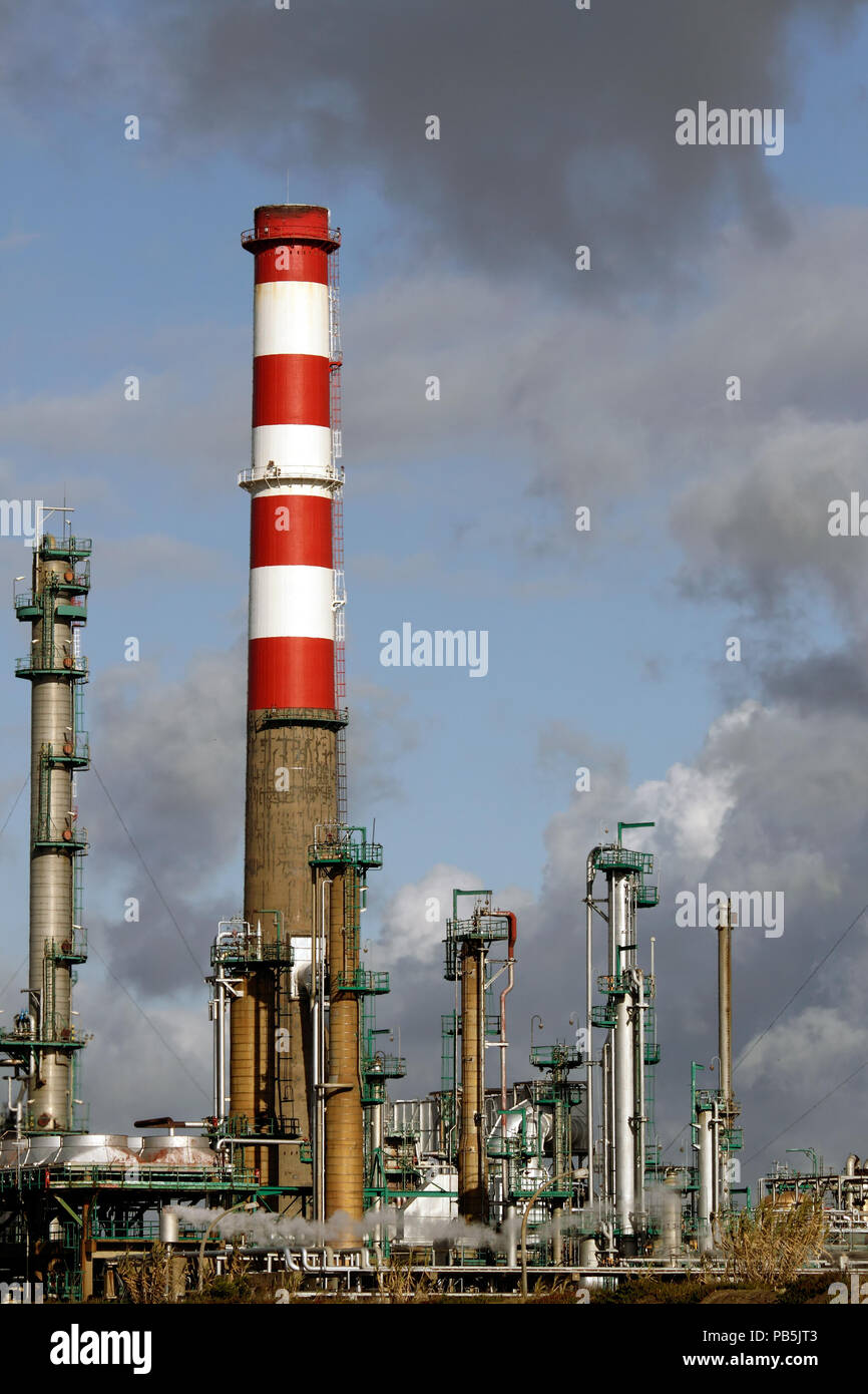 Industrial pipes and chimneys from a big oil refinery seeing steam and ...