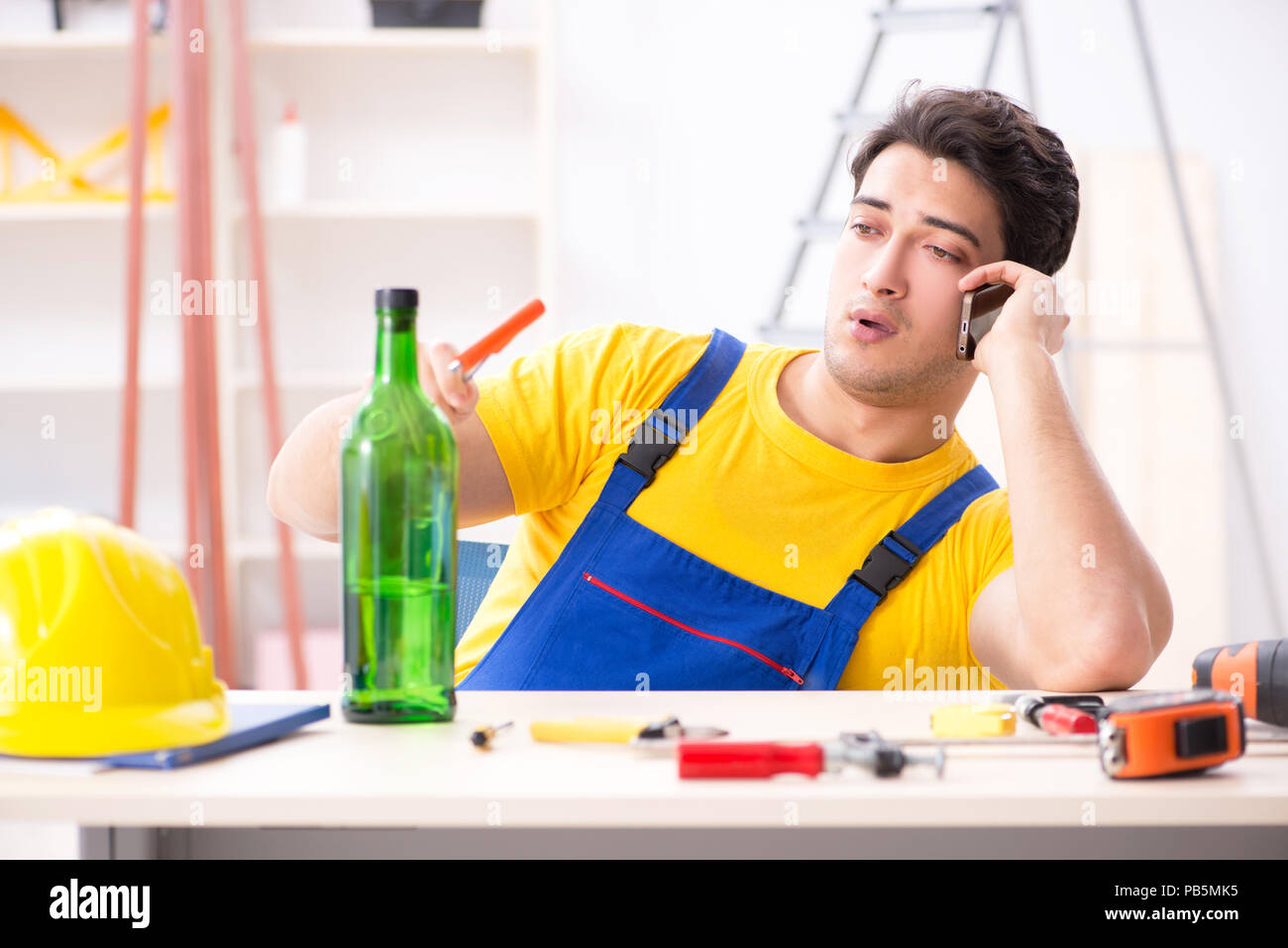 Drunk engineer working in the workshop Stock Photo - Alamy