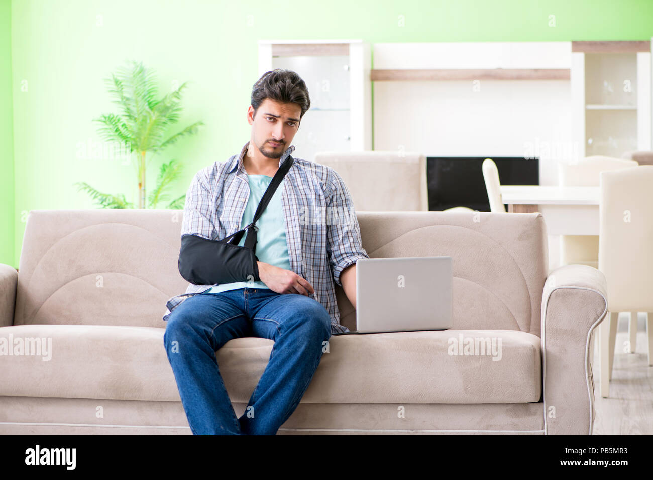 Young student man with hand injury sitting on the sofa Stock Photo - Alamy