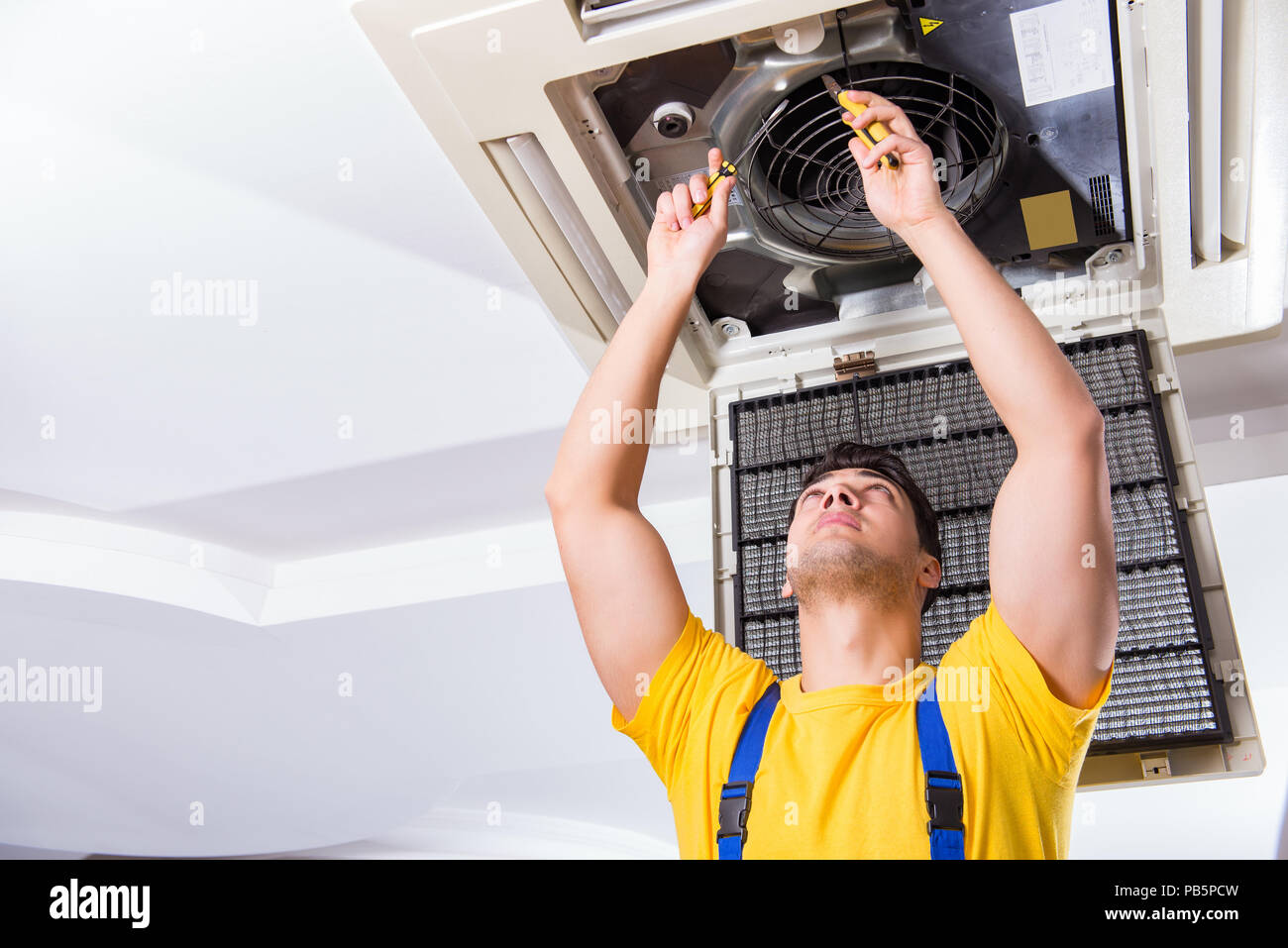 Repairman repairing ceiling air conditioning unit Stock Photo - Alamy