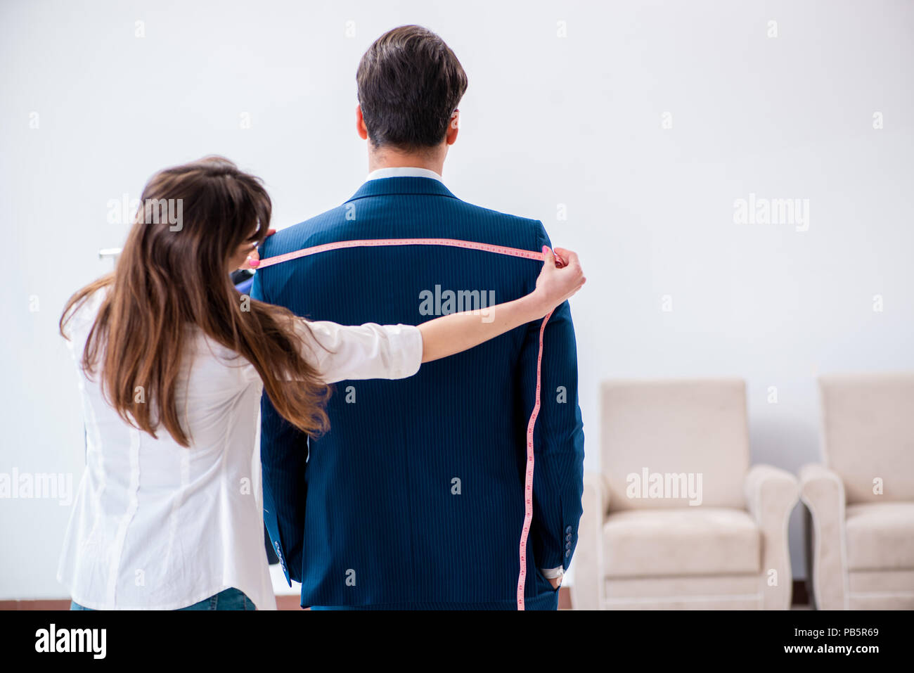 Professional tailor taking measurements for formal suit Stock Photo - Alamy