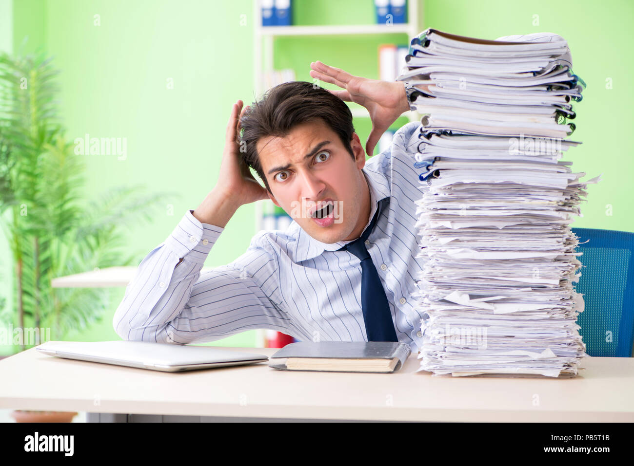 Businessman having problems with paperwork and workload Stock Photo - Alamy
