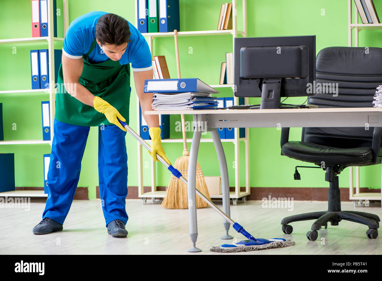Male handsome professional cleaner doing mopping in the office Stock ...