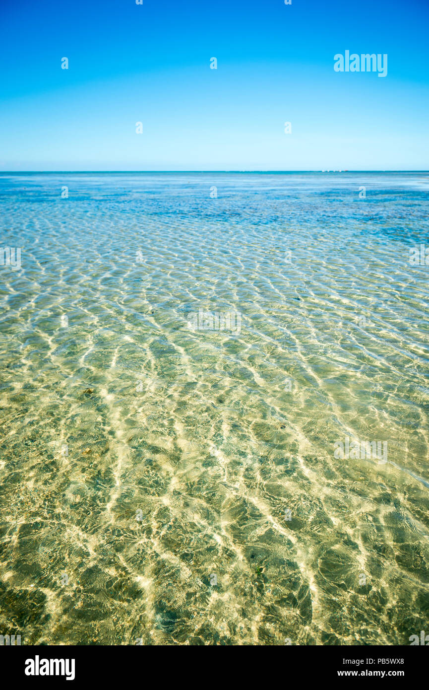Amazing calm, clear lagoon waters ripple on a sand bar off a beautiful ...