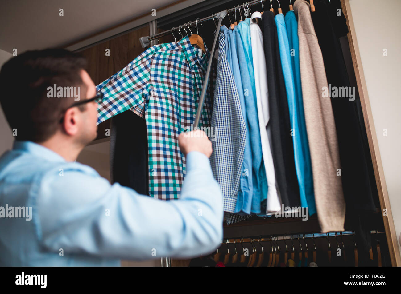 Man choosing shirt from wardrobe hi-res stock photography and images ...