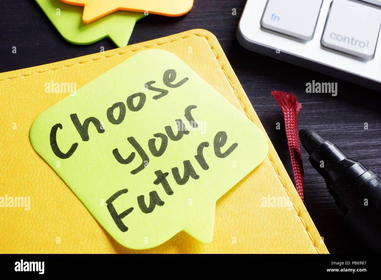 Choose your future written on a memo stick and pen Stock Photo - Alamy