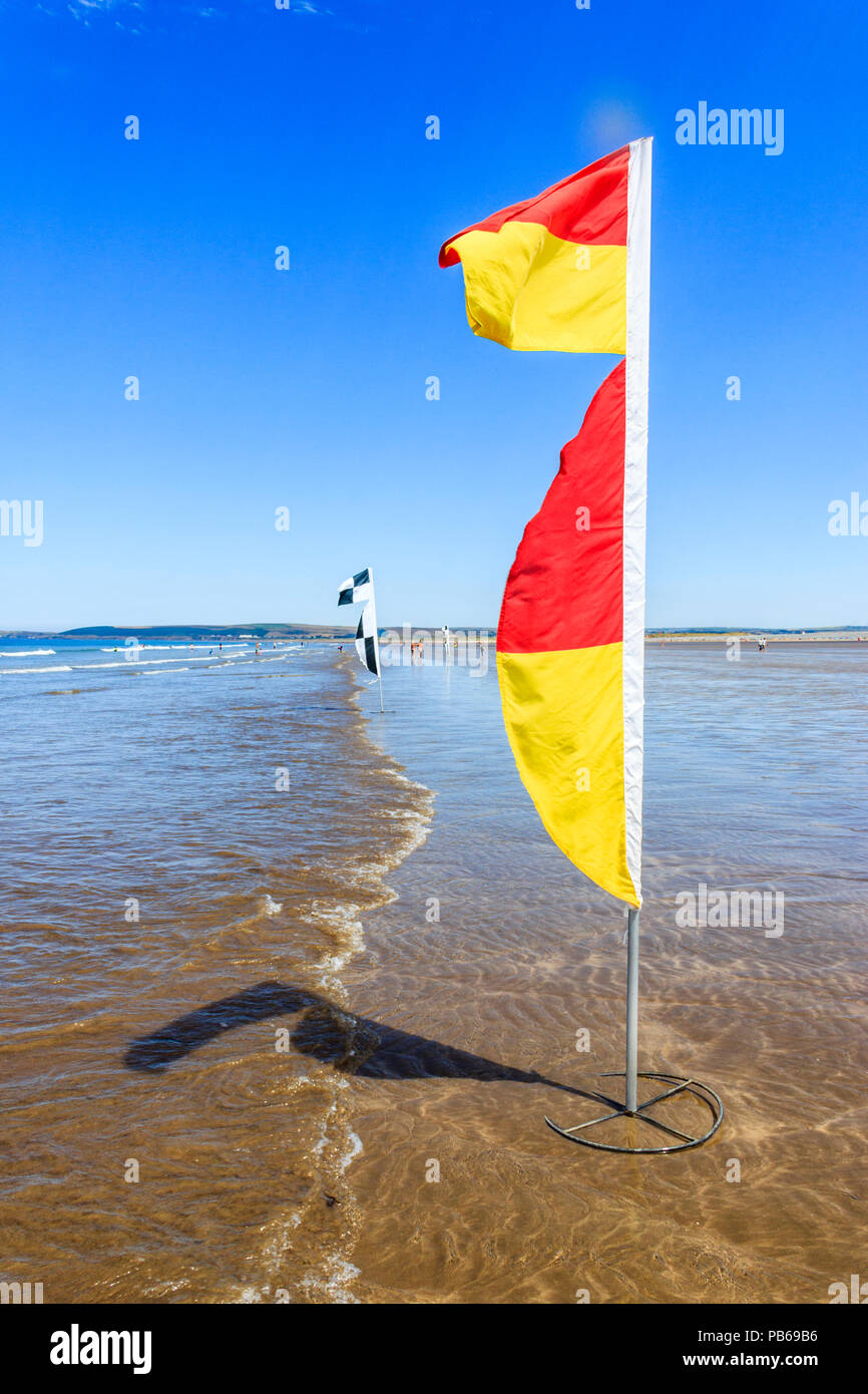RNLI Safety marker flags on the beach at Westward Ho!, Devon, UK Stock ...