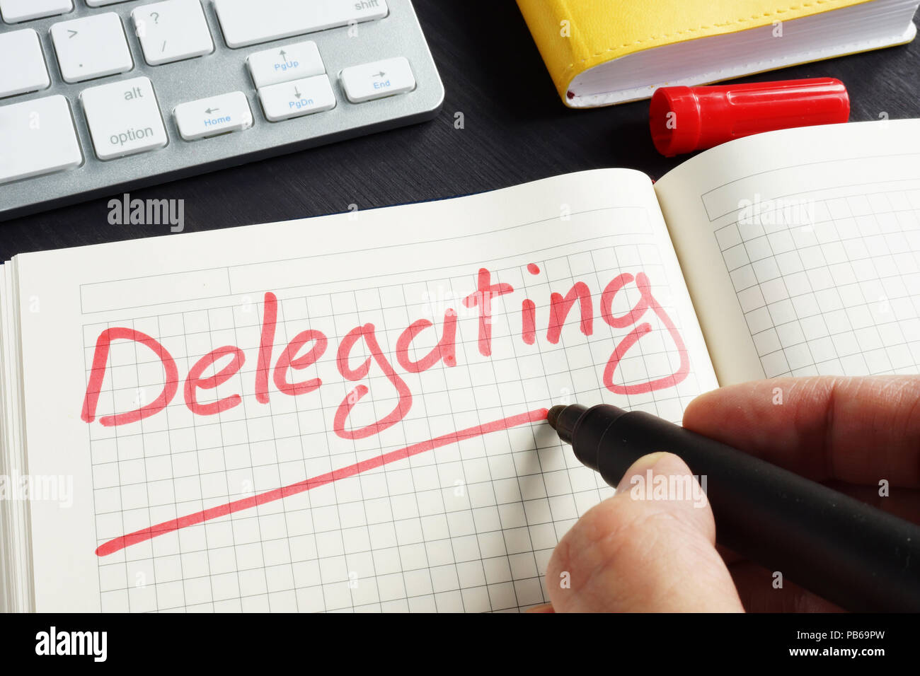 Man is writing delegating in the notepad. Delegate concept Stock Photo ...