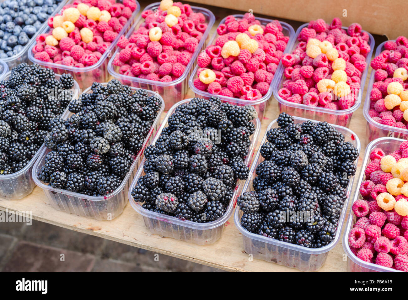 fresh berries, blackberries and red and yellow raspberries in plastic ...