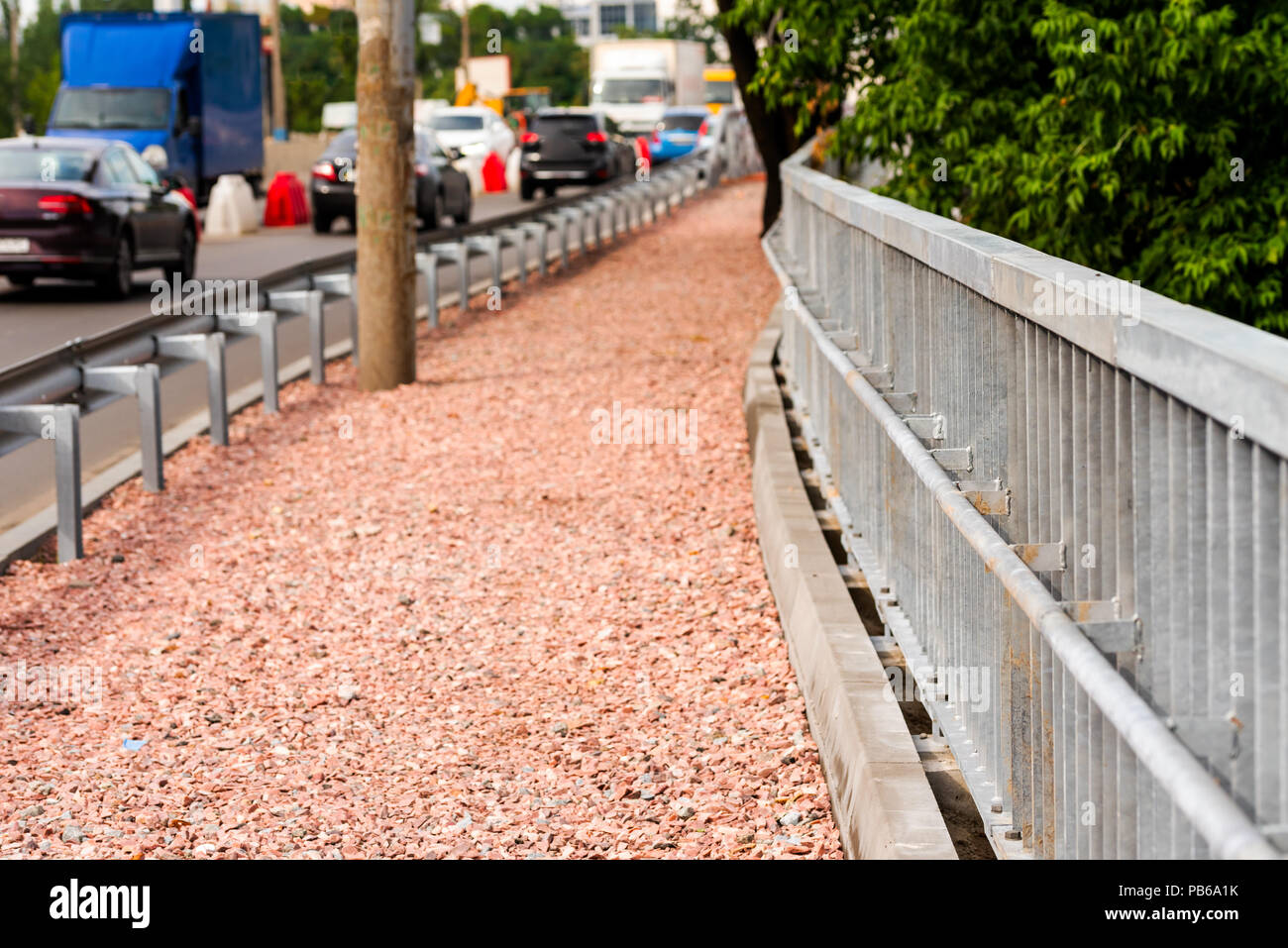 pavement with metal fence and gravel for repair Stock Photo - Alamy