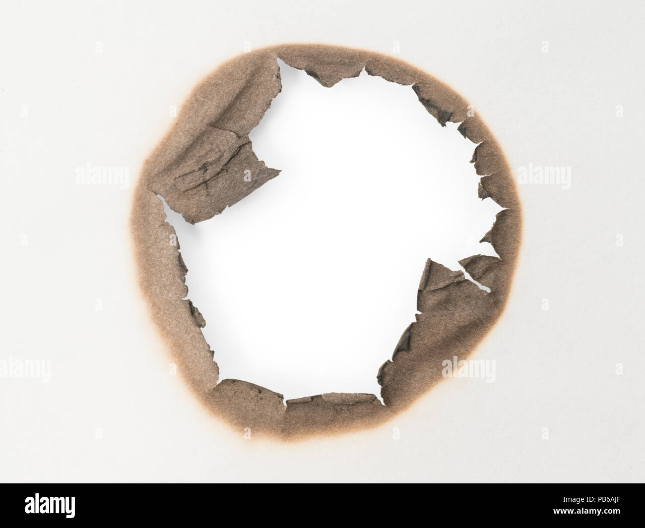 Burned hole in the paper sheet. Isolated on white Stock Photo - Alamy