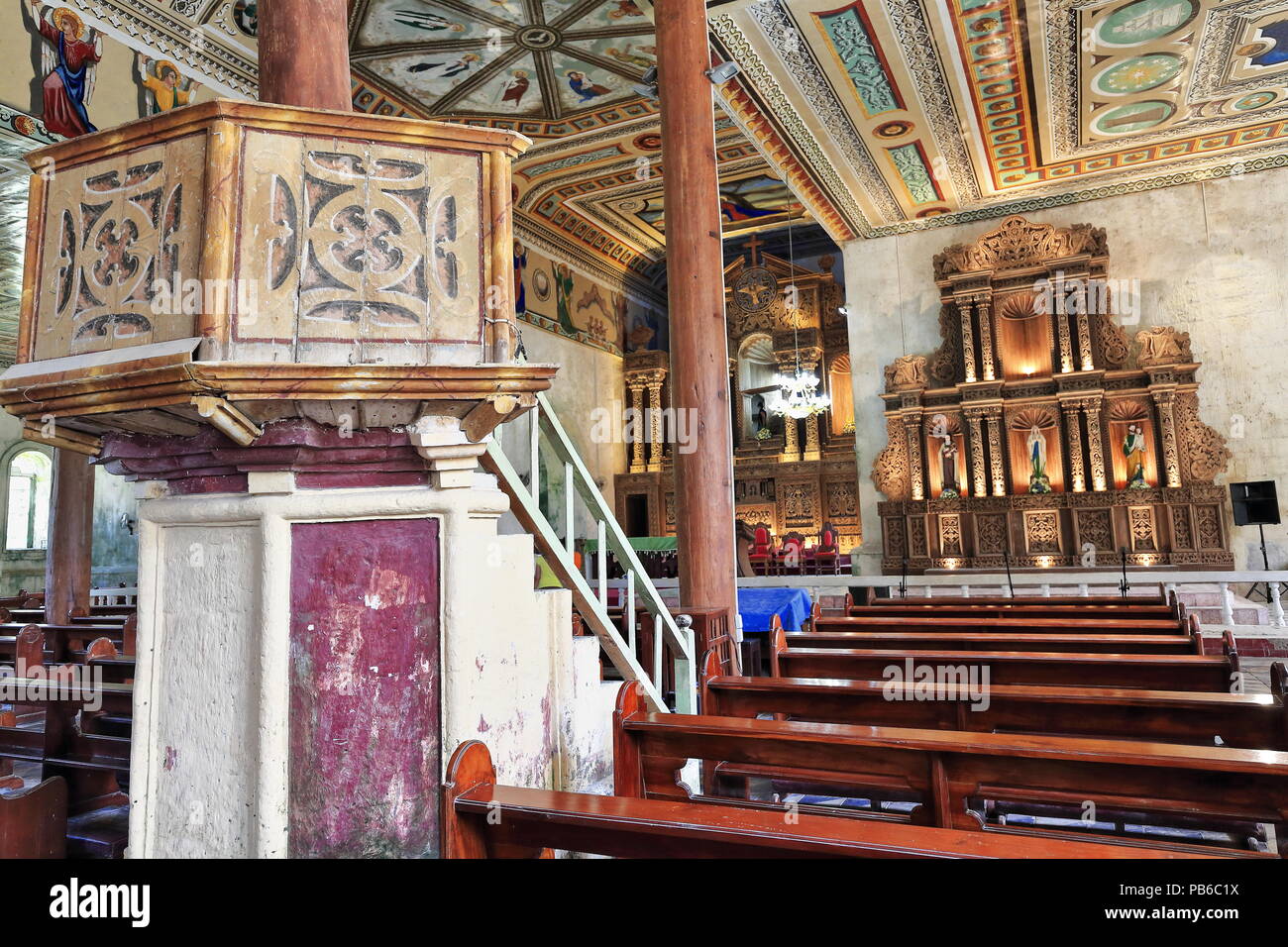Large tree log-pillars mark the nave and hold the old pulpit and tin ...