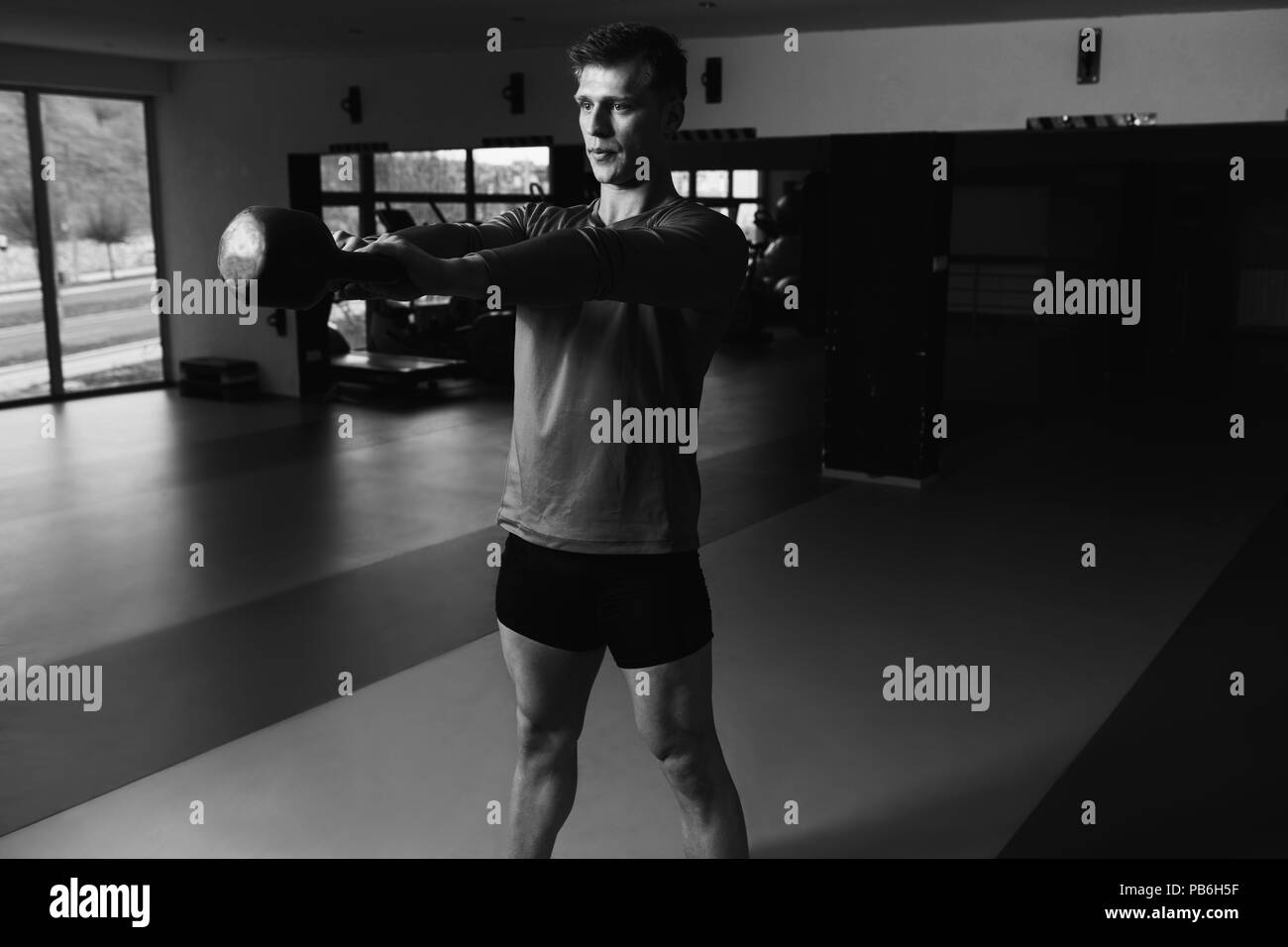 Young Man Exercising With Kettle Bell And Flexing Muscles - Muscular ...