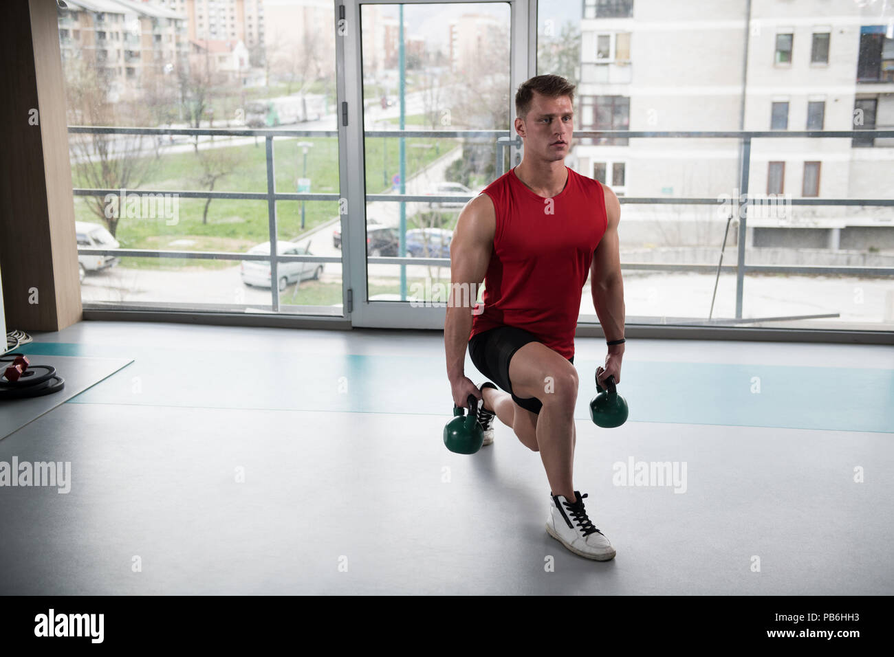 Young Man Working Out With Kettle Bell In A Dark Gym - Bodybuilder ...
