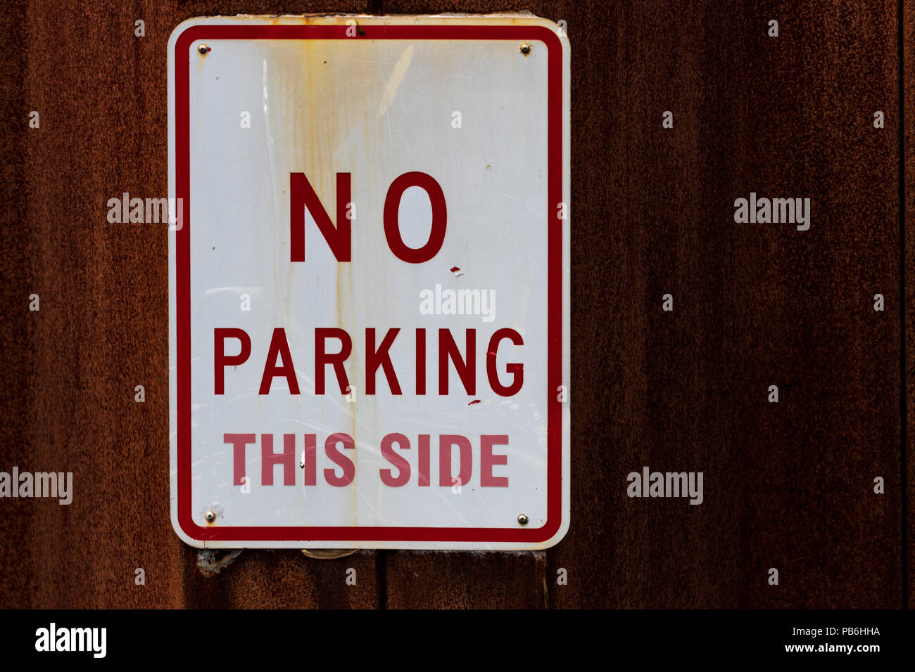 Old faded worn metal no parking this side sign on a rusty post Stock ...