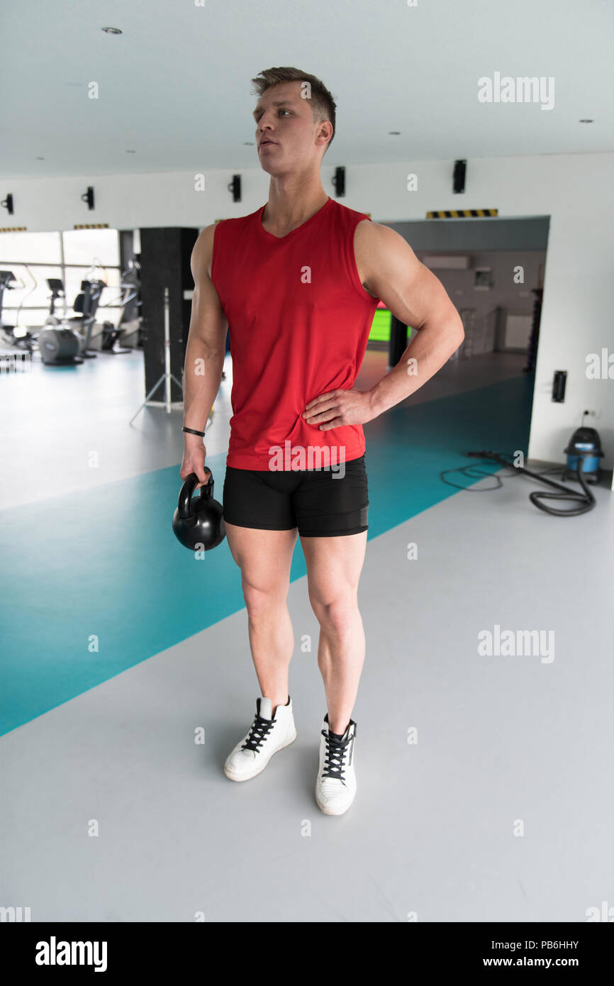 Young Man Exercising With Kettle Bell And Flexing Muscles - Muscular ...
