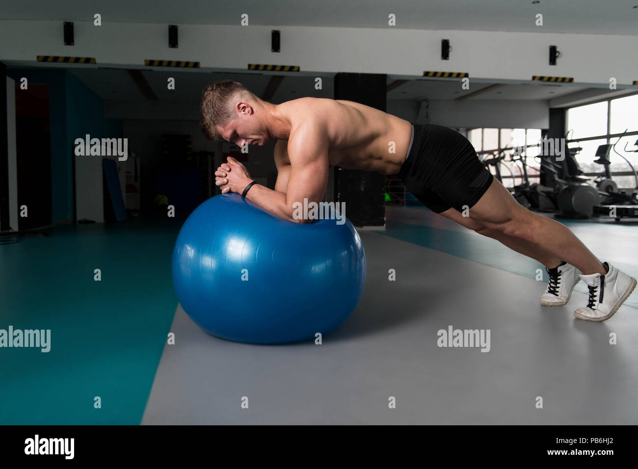 Young Man Athlete Doing Abs Exercise On Ball As Part Of Bodybuilding ...