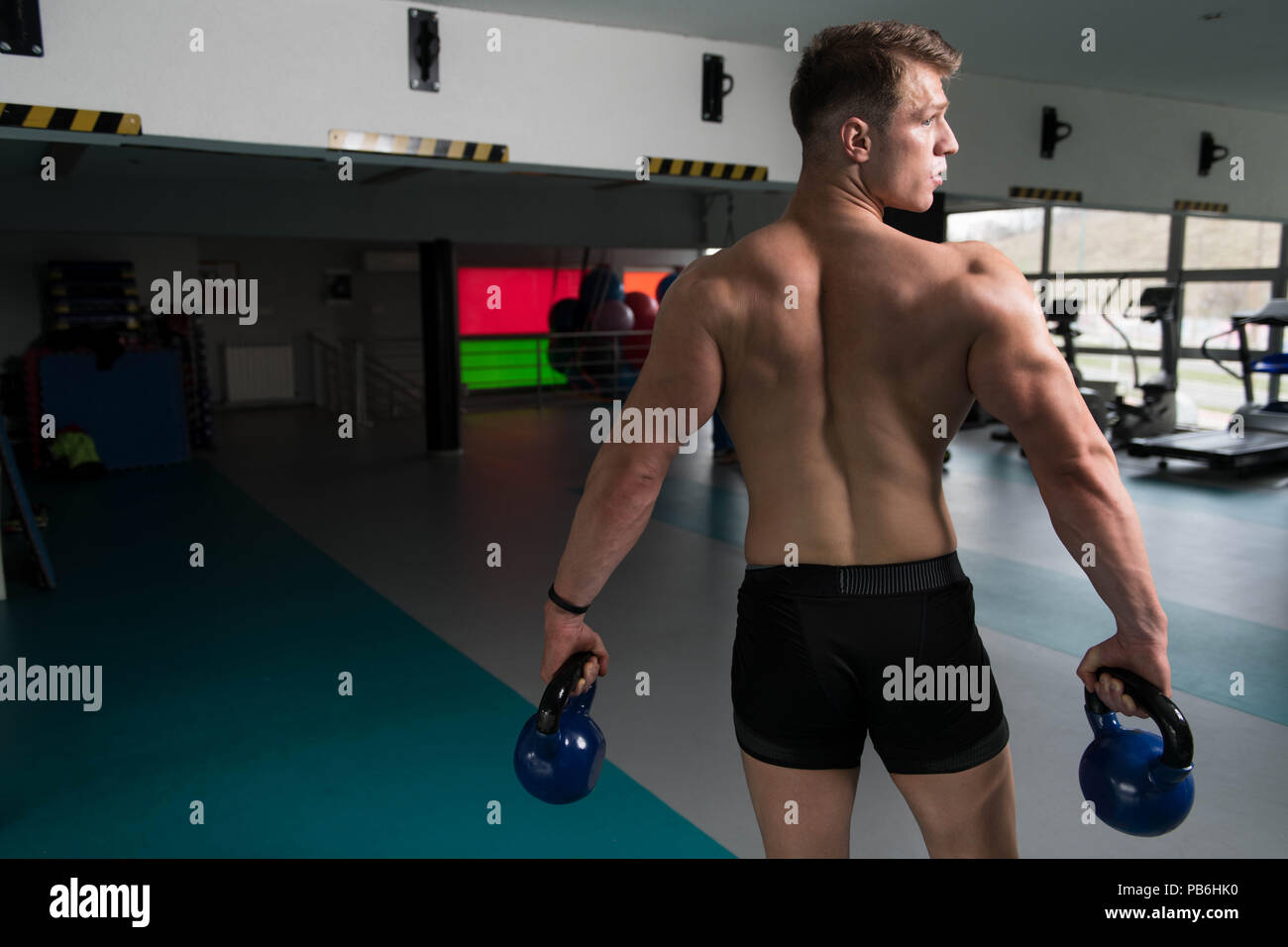 Young Man Exercising With Kettle Bell And Flexing Muscles - Muscular ...