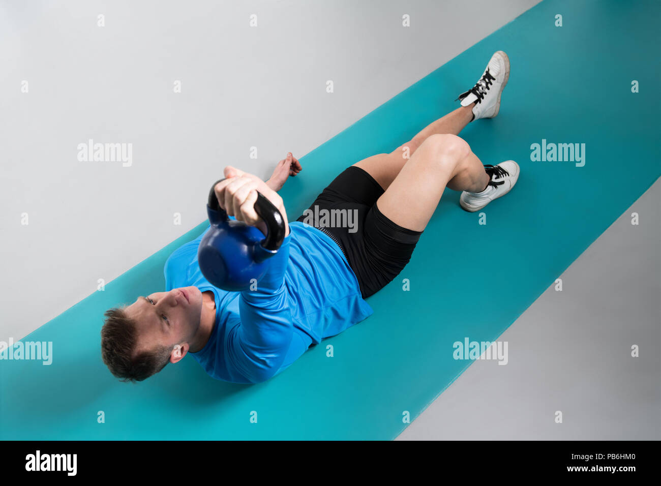 Young Man Exercising With Kettle Bell And Flexing Muscles - Muscular ...