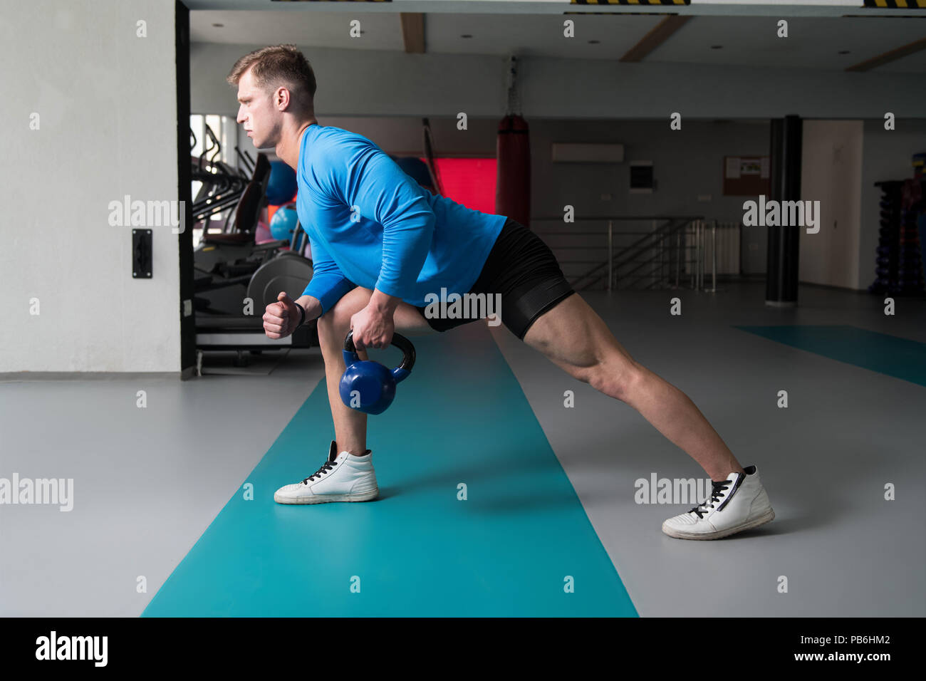Young Man Working Out With Kettle Bell In A Dark Gym - Bodybuilder ...