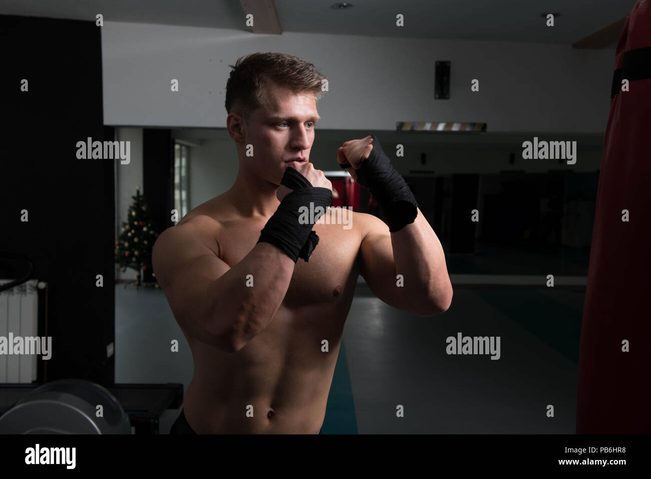 Young Man Boxing On Bag - Boxing In A Gym - The Concept Of A Healthy ...
