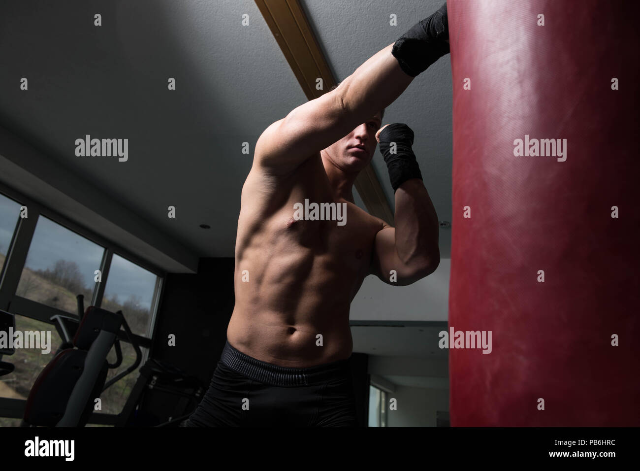 Young Man Boxing On Bag - Boxing In A Gym - The Concept Of A Healthy ...