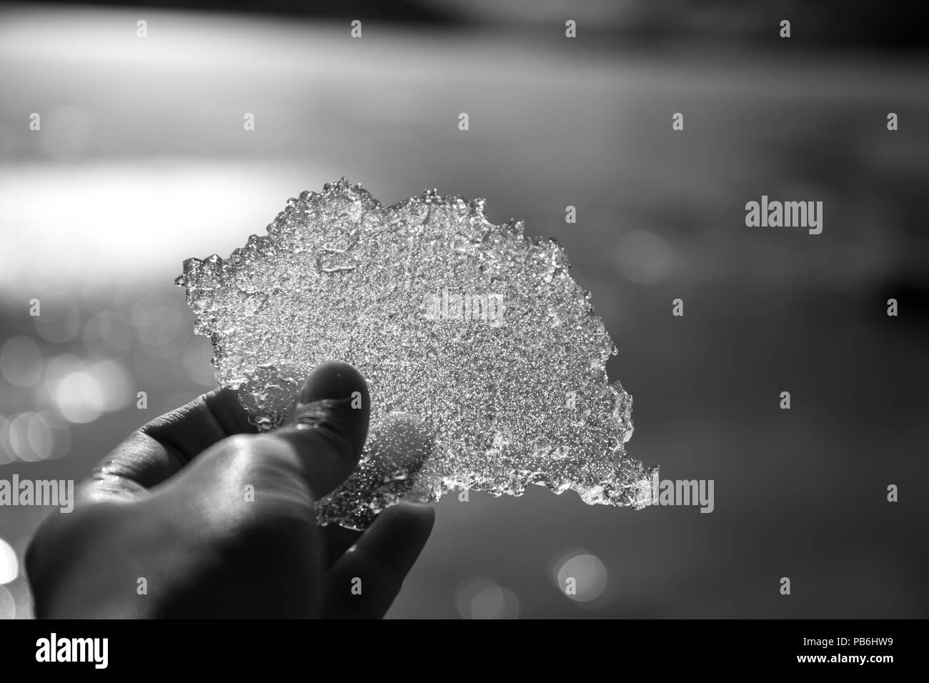 Hand holding a piece of broken ice up in the sun Stock Photo - Alamy