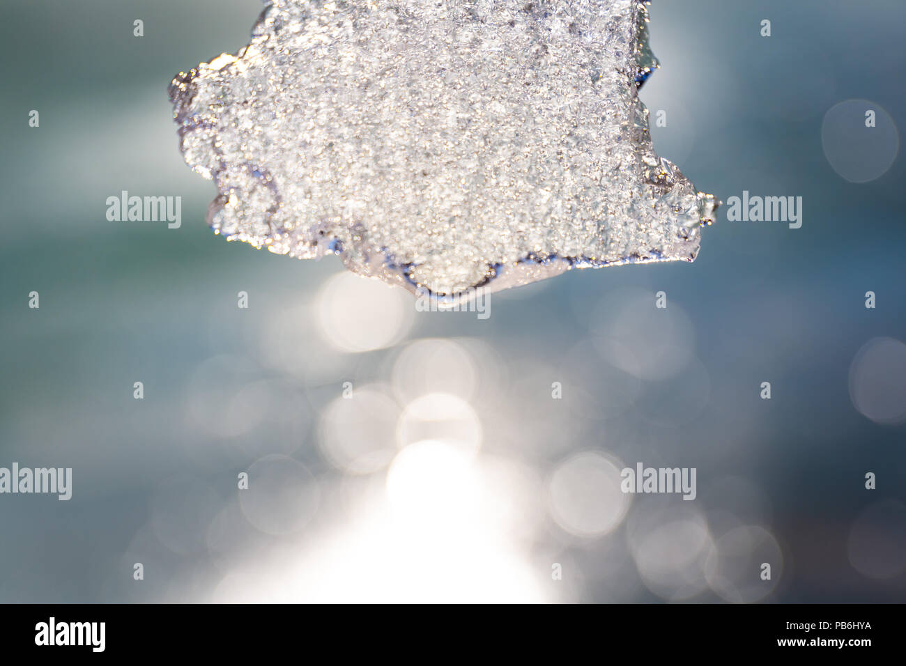 Hand holding a piece of broken ice up in the sun Stock Photo - Alamy