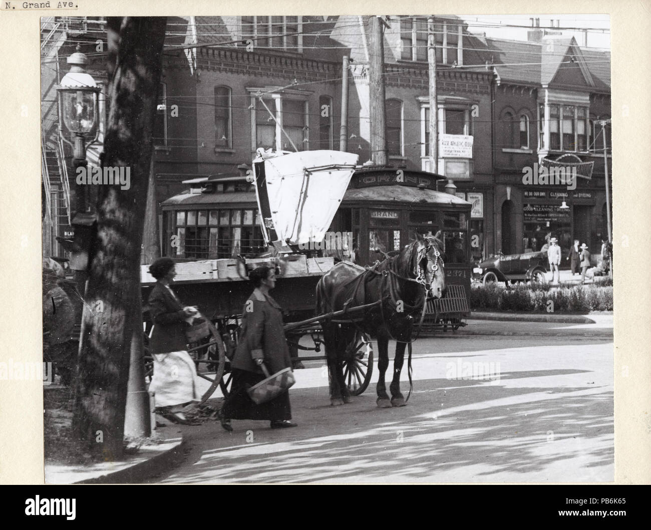 1782 Two women walking across East Grand Avenue in front of a horse ...
