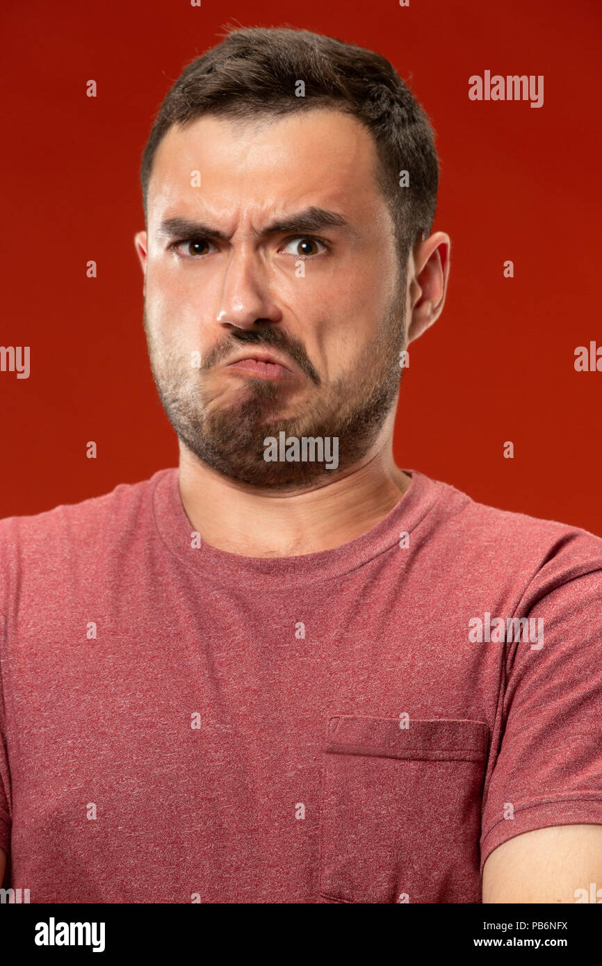 The young emotional angry man screaming on red studio background Stock ...